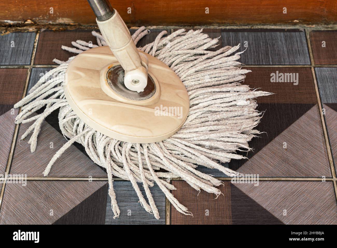 View of used cleaning mop with micro fiber on ceramic tile floor in a ...