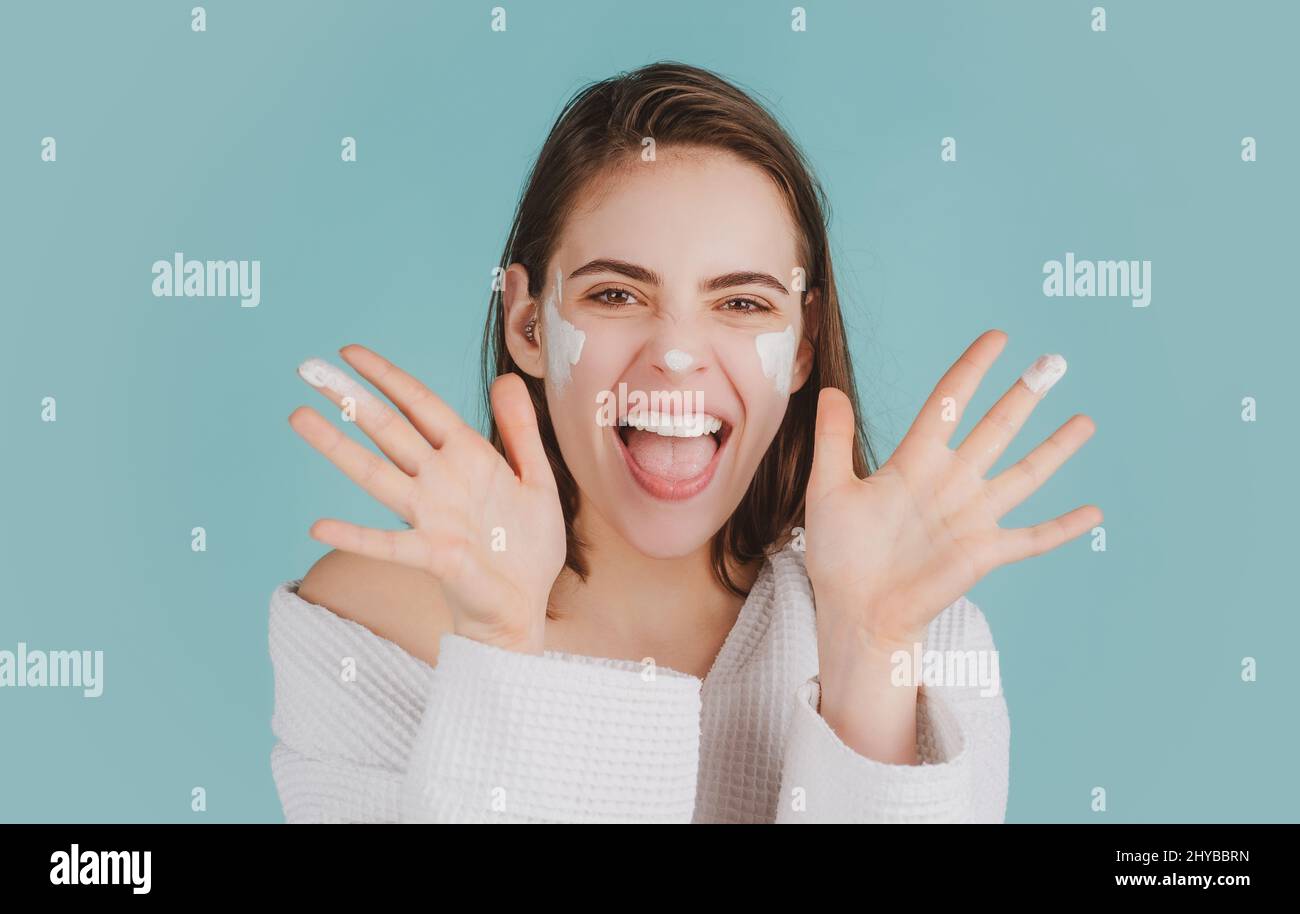 Beautiful amazed woman applying face cream, female skin care, close up ...