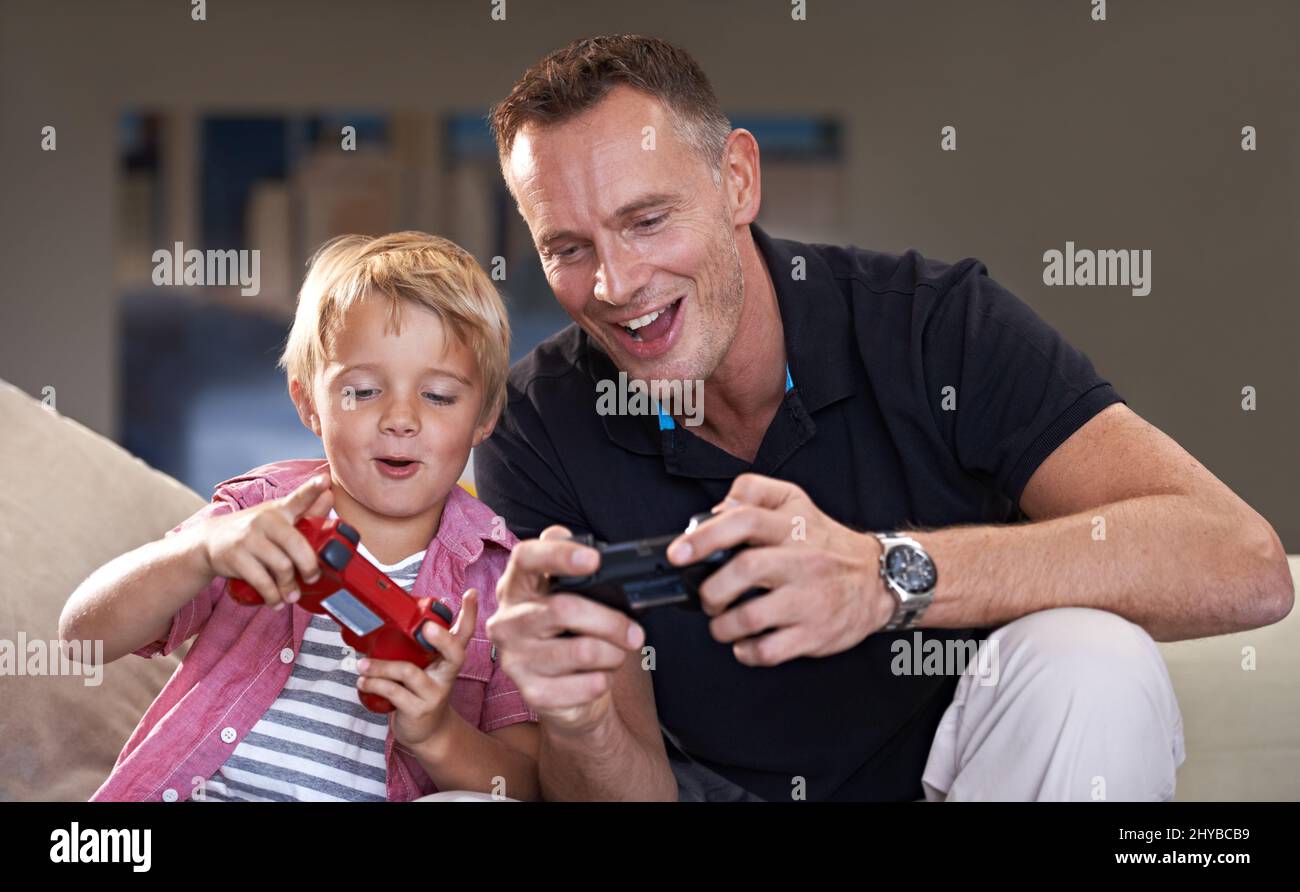 They are avid gamers. A father and his son playing video games Stock ...