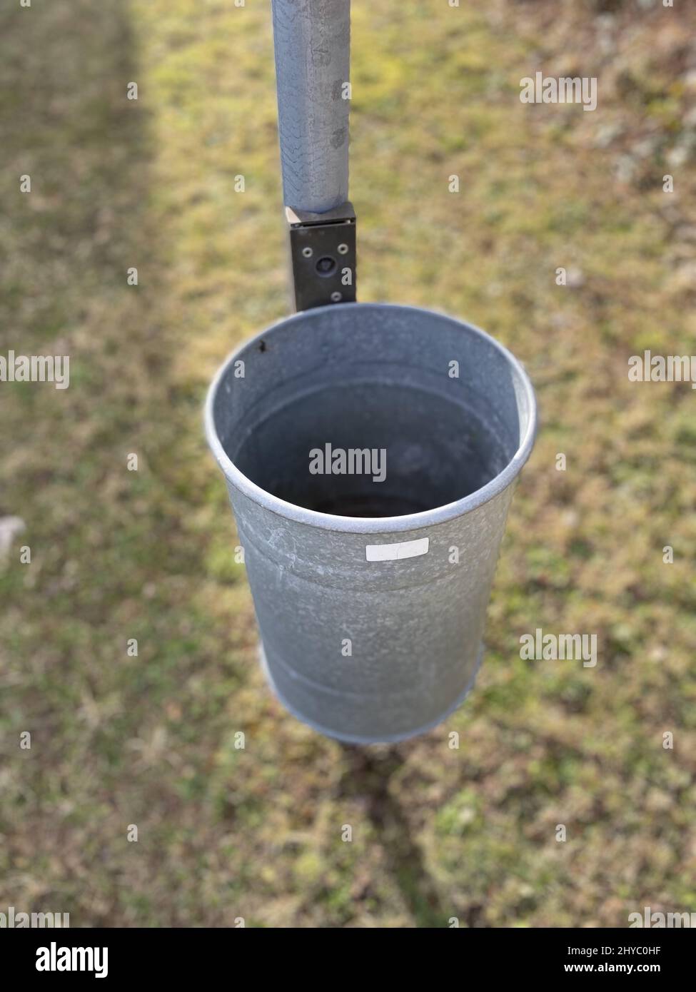 Vertical shot of an empty stainless bucket on a pole Stock Photo - Alamy