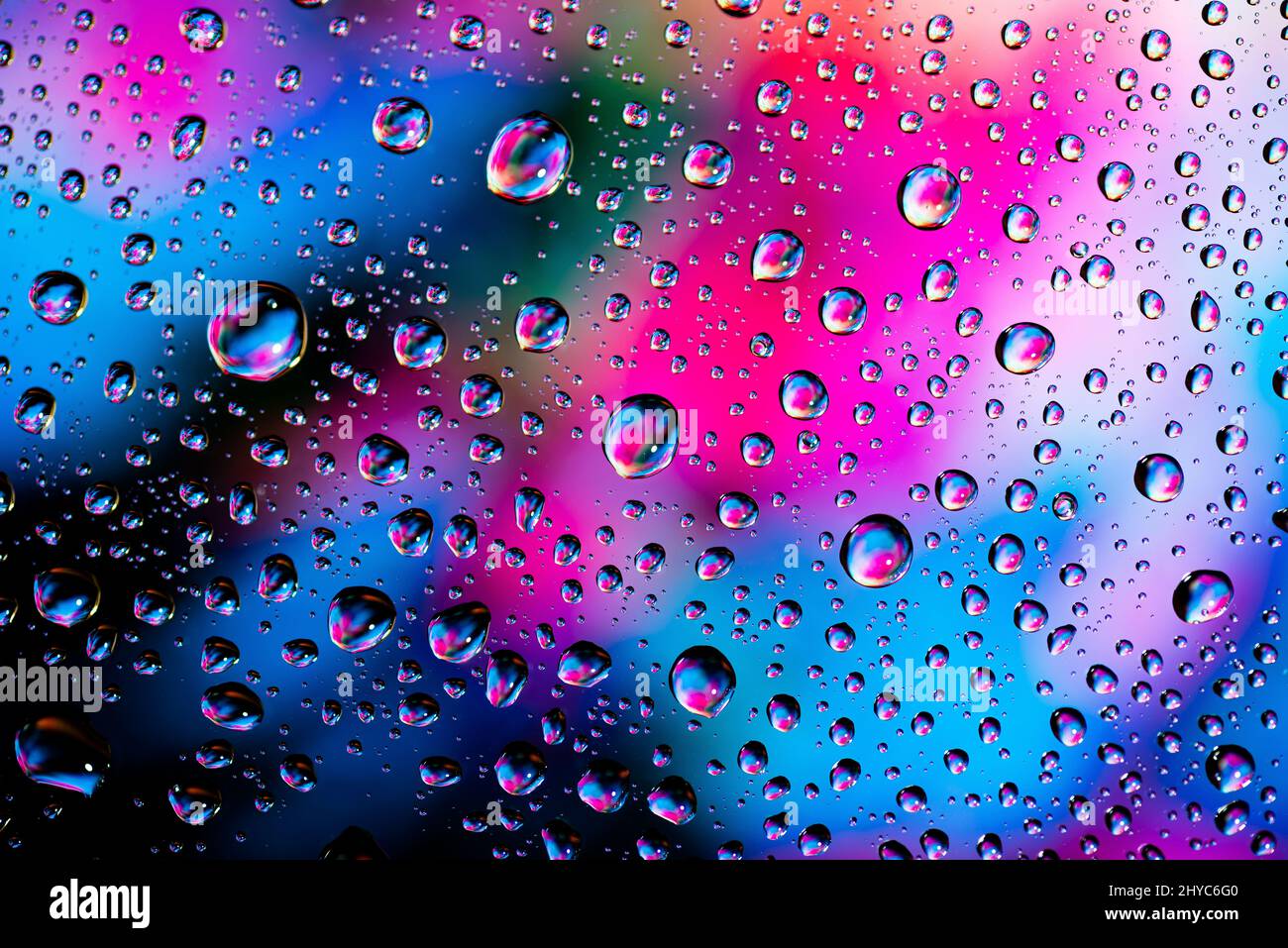 Closeup shot of many water drops with multicolored on the background ...