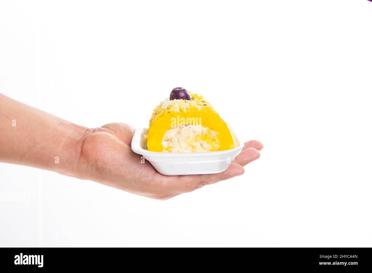 Hand holding a Peruvian food called causa made with chicken and mashed ...