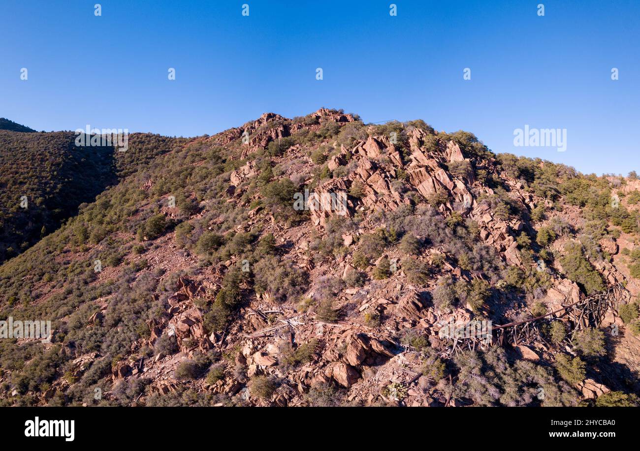Large rocky mountain with trees and the ruins of a mine in Jerome ...