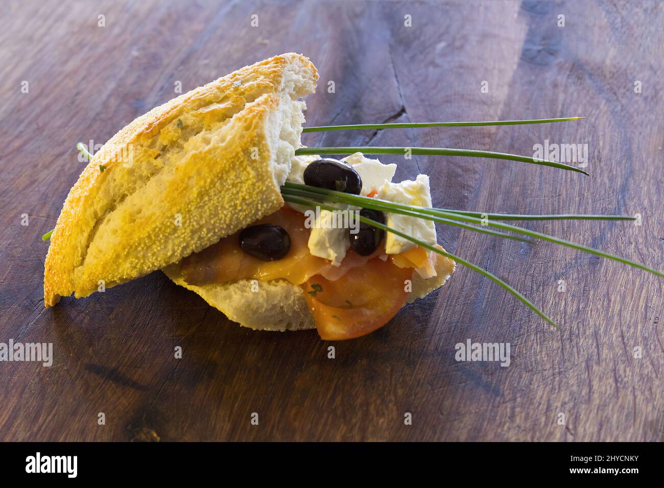 Closeup of a sandwich with a bread, slices of beacon, cheese, pickled ...