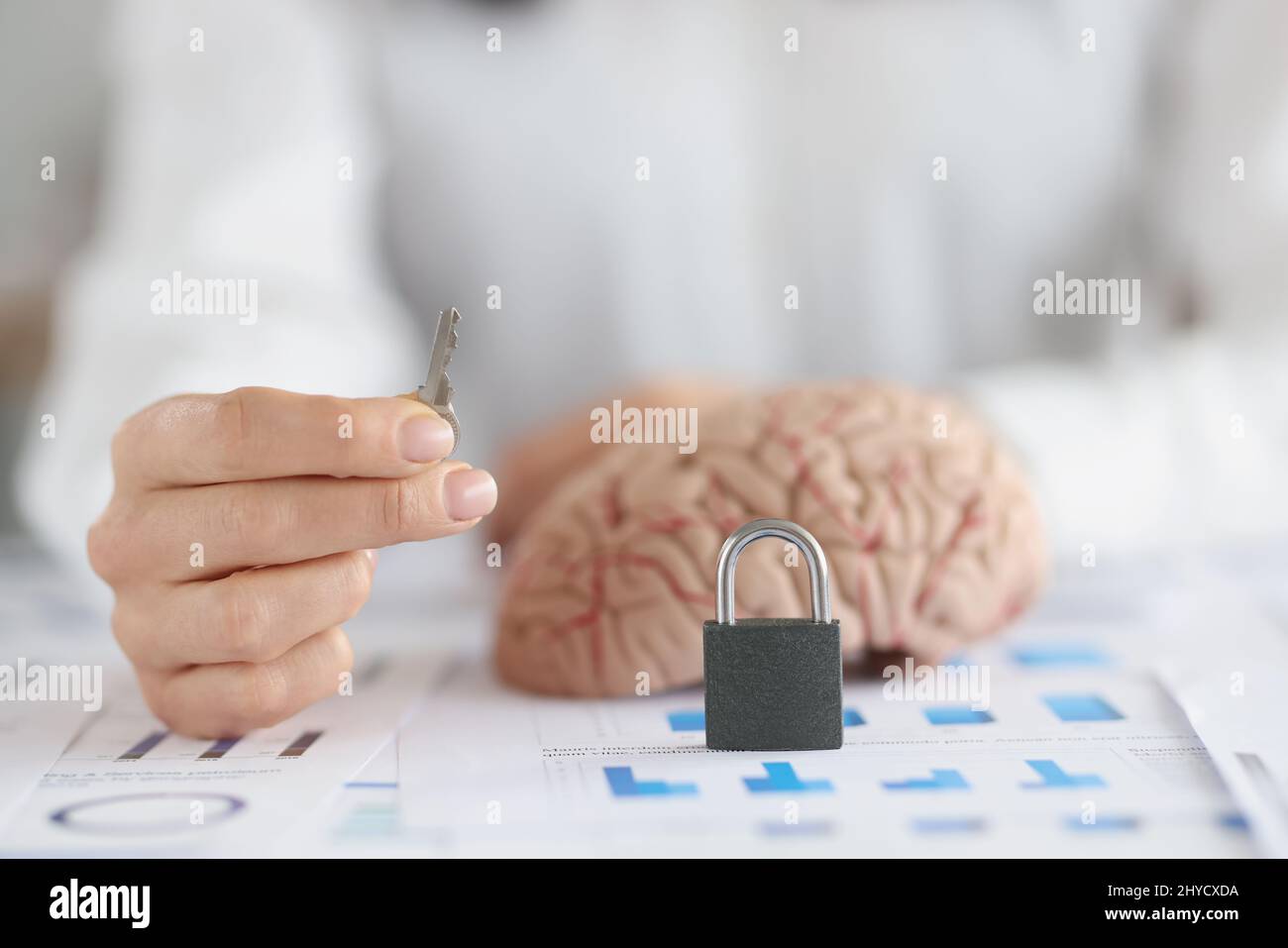 Woman hold key, lock and human brain on desk, symbol as key to someones ...