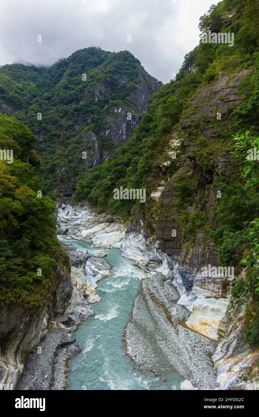 Steep and lush mountains, deep gorge and rocky river at the Taroko ...