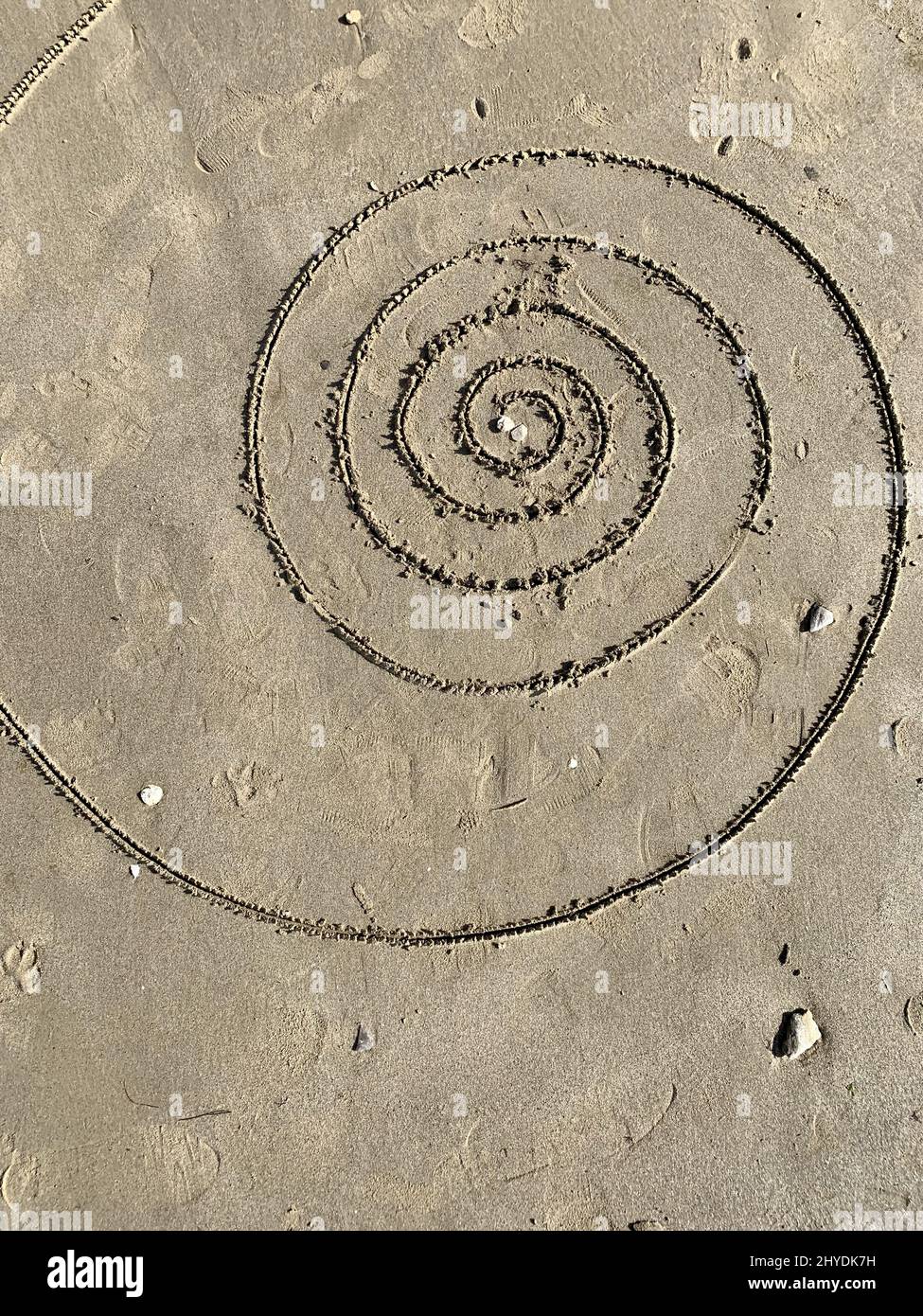 Vertical shot of a spiral-like shape on the sand of the beach Stock ...