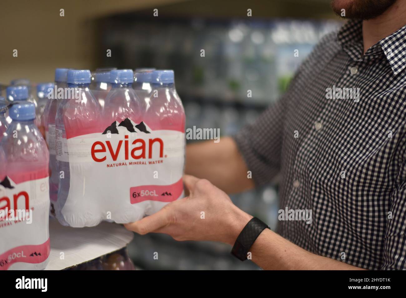 Closeup shot of a worker stacking Evian water bottles in the shelf at the store Stock Photo - Alamy