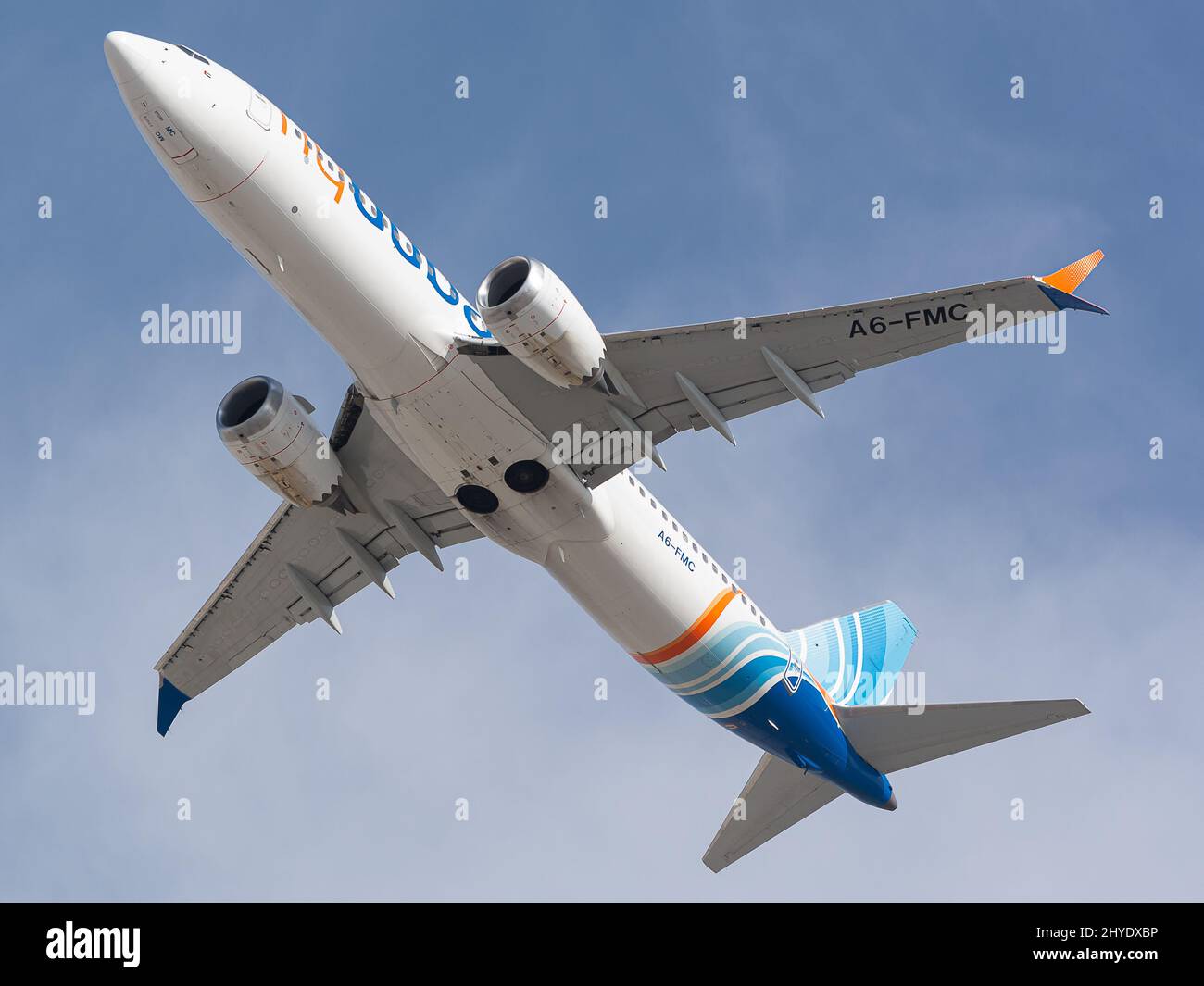 Low-angle shot of a Boeing 737 max Fly Dubai flying against the blue ...