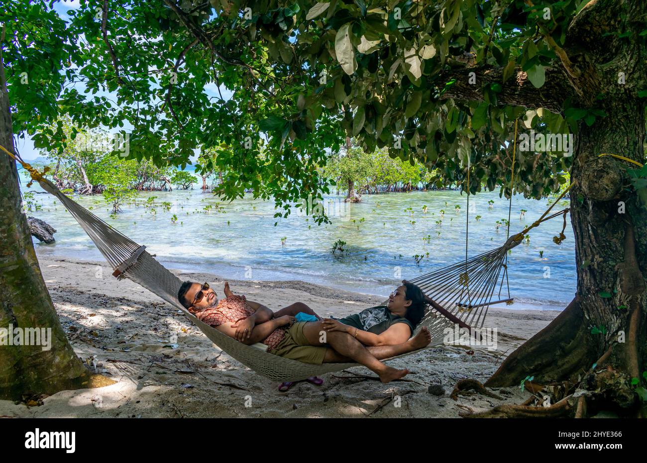 A couple relaxing on the beach, Havelock Island, Andaman, India Stock ...