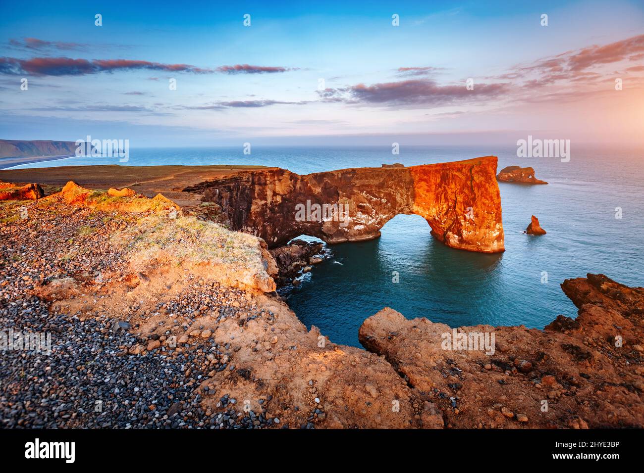 Amazing black arch of lava standing in the sea on small peninsula ...