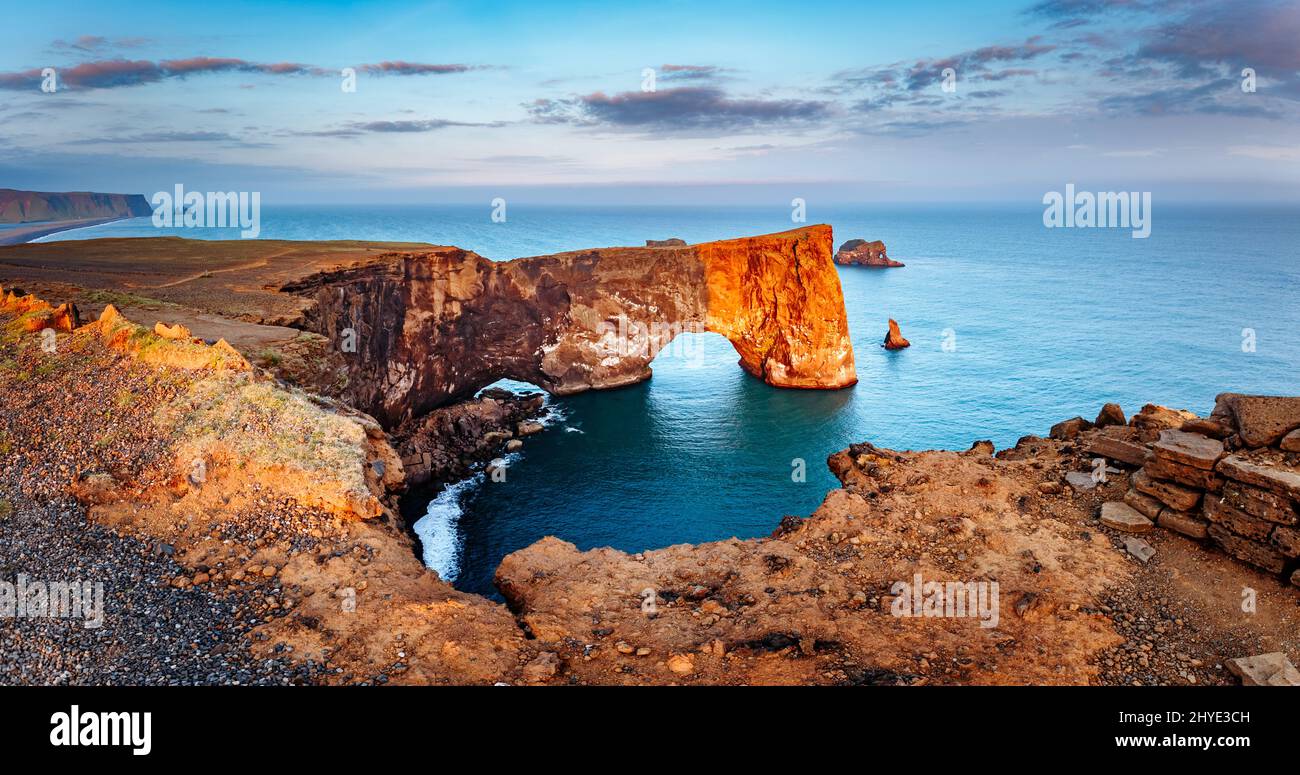 Amazing black arch of lava standing in the sea on small peninsula ...
