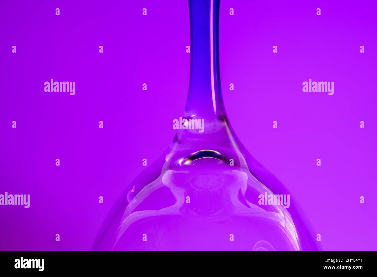 Glass of wine turned down on the purple background Stock Photo - Alamy