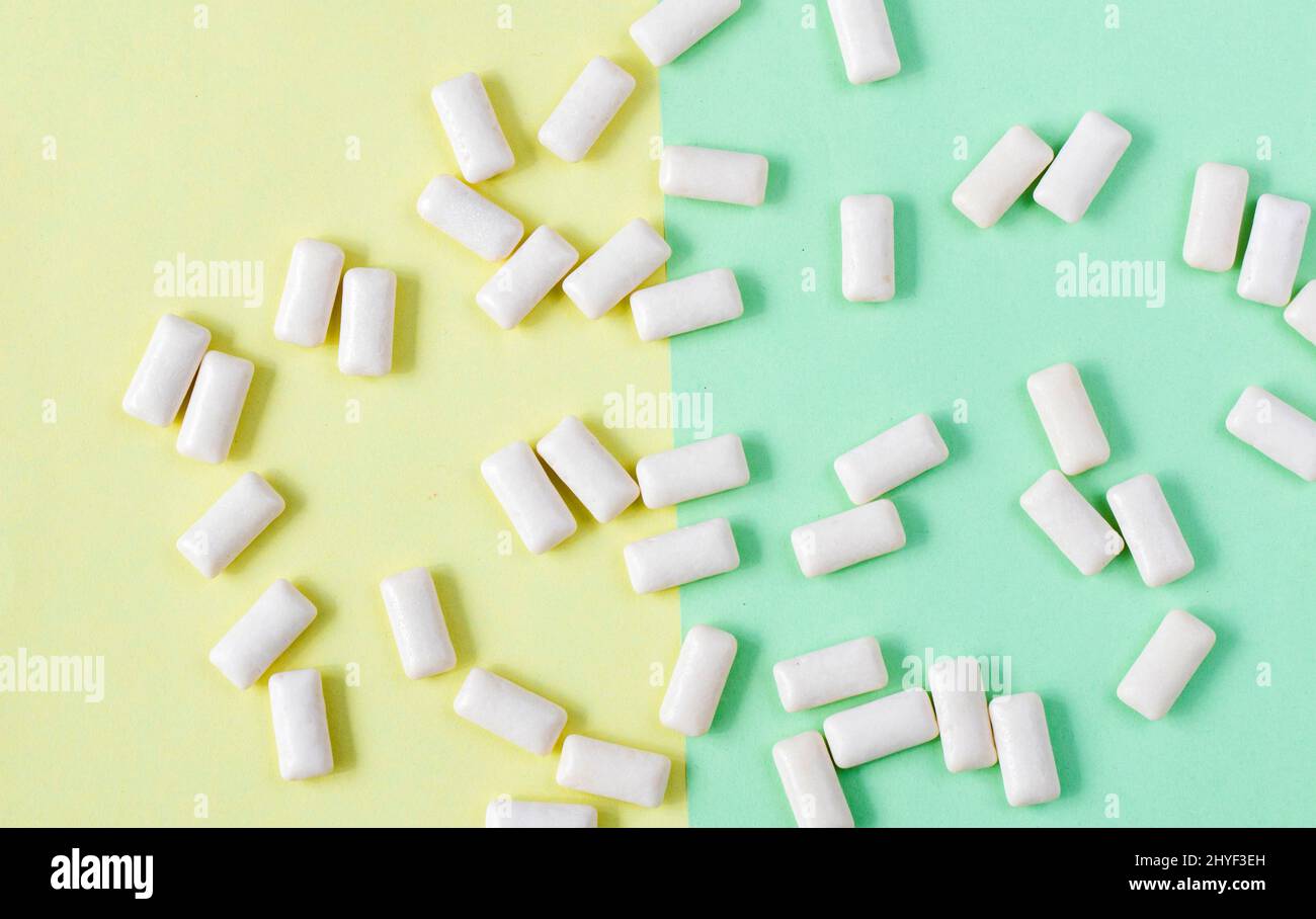 White chewing gums on the yellow and green background, high angle view ...