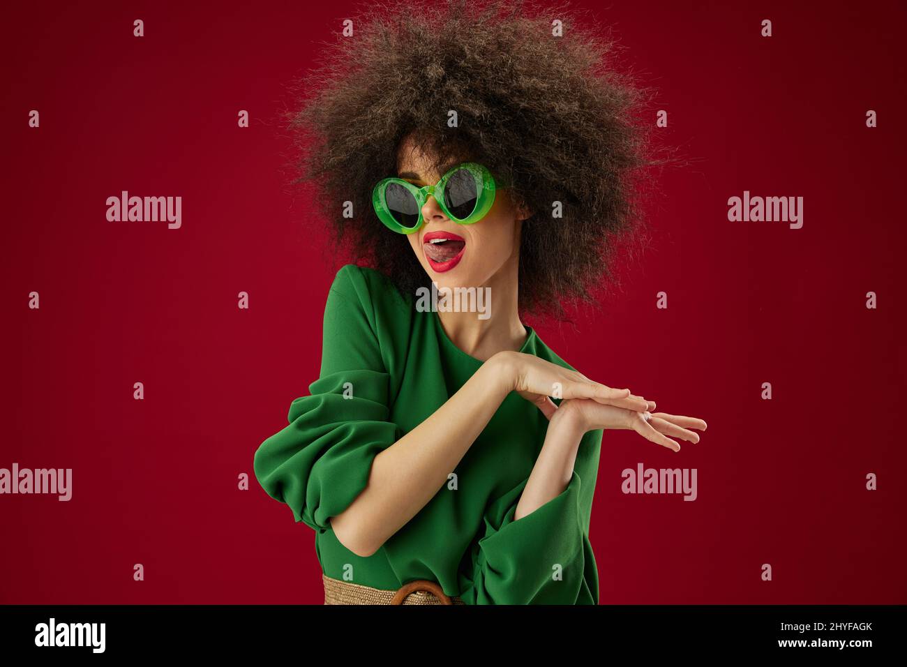pretty woman in green afro dress hairstyle red background Stock Photo ...