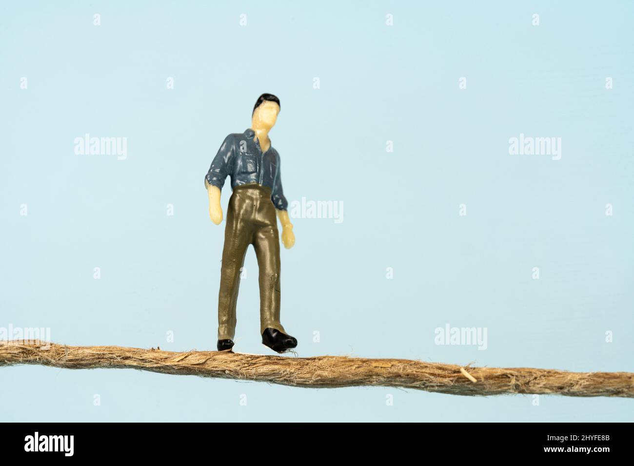 A miniature model man walks on a rope like a tightrope walker Stock ...
