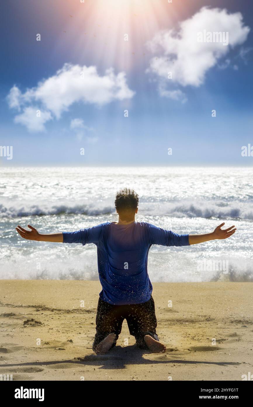 Vertical wallpaper of a person kneeled at a beach looking at the sun ...