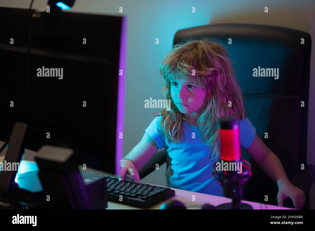 Child learning online at night, using desktop computer in living room ...