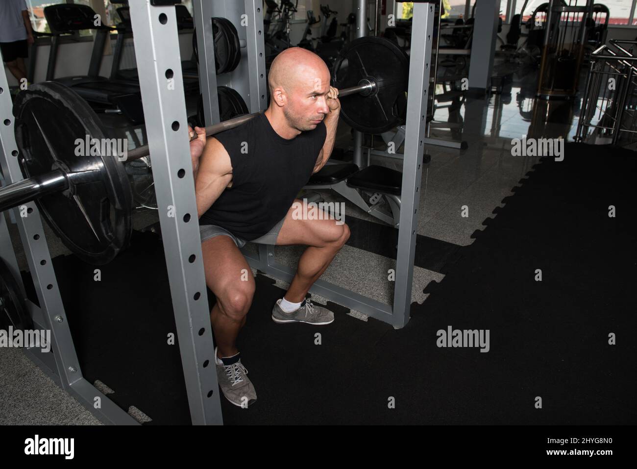 Man Working Out Legs With Barbell In A Gym - Front Squat Exercise Stock ...
