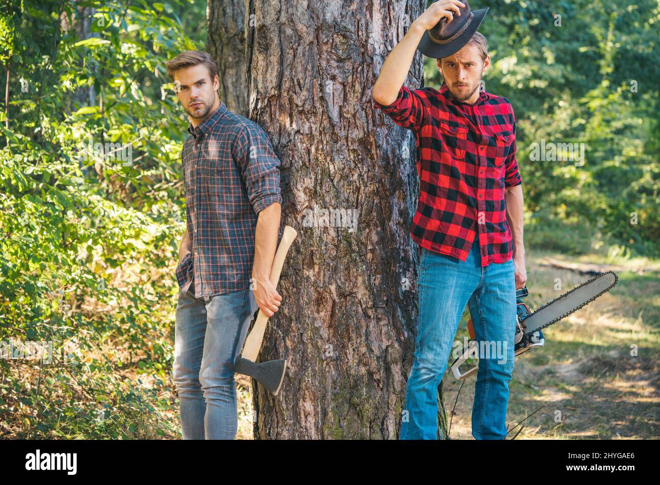 Man with axe in forest. Lumberjack woodcutter in a plaid shirt ...
