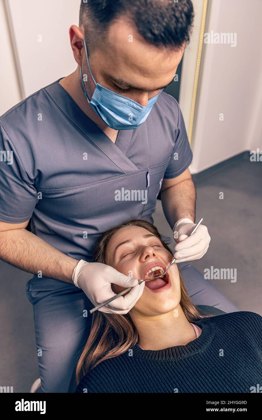 Stomatology and health care concept, male dentist with mirror checking ...