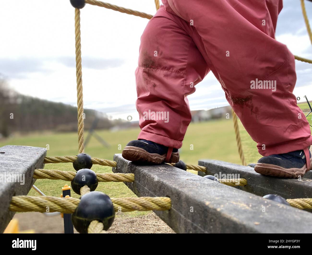 Closeup of a child's feet carefully stepping on the wooden bridge with ...