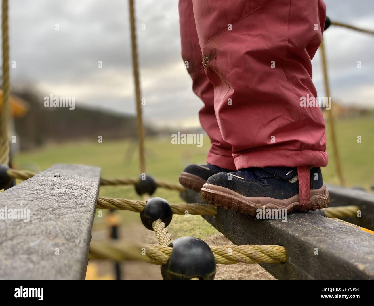 Closeup of child's feet carefully stepping on the wooden bridge with ...