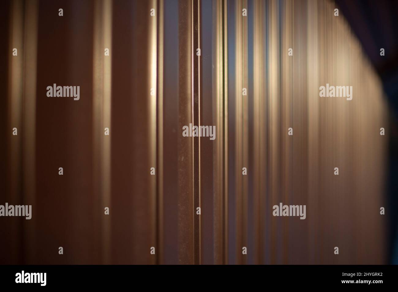 Texture of steel fence. Profile sheet is brown. Fence details. Blurry ...