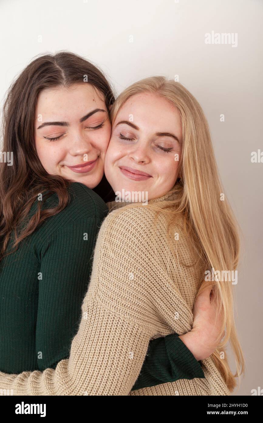 Two young female friends hugging each other Stock Photo - Alamy