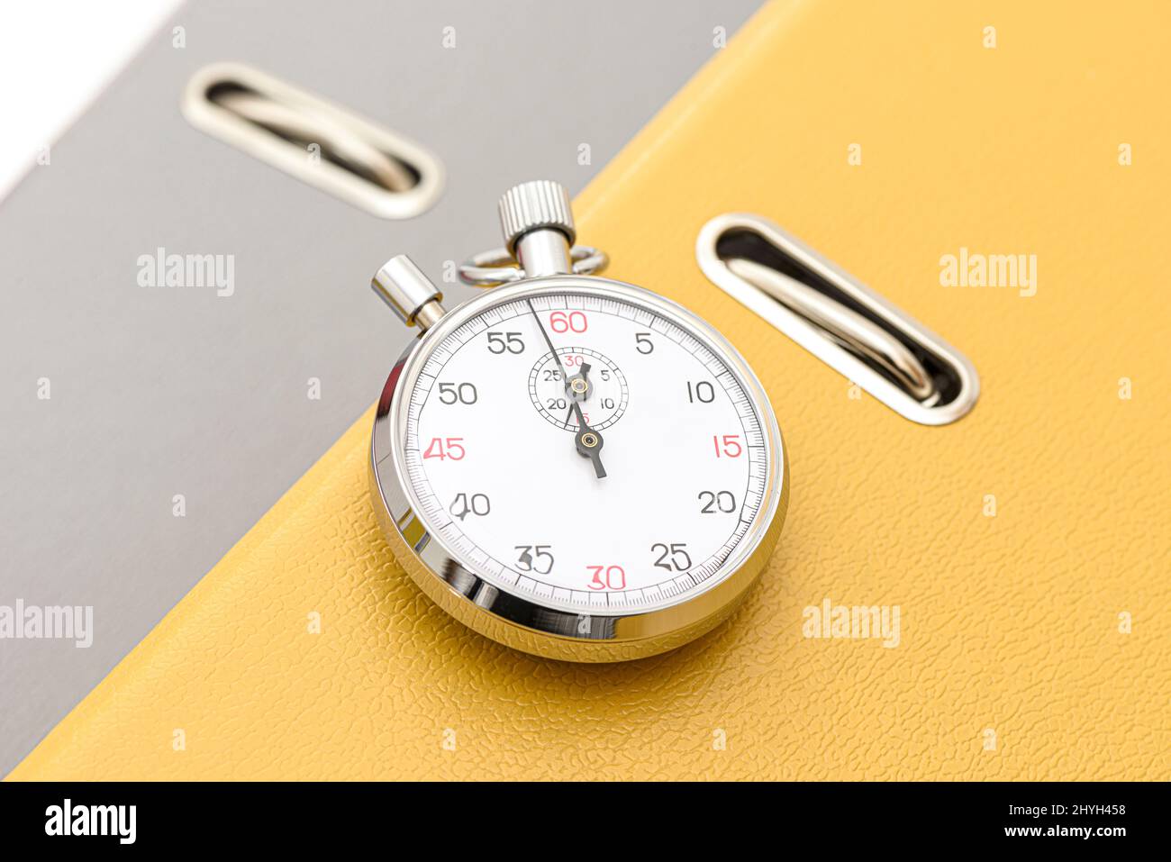 Yellow office folder on the chronometer Stock Photo - Alamy
