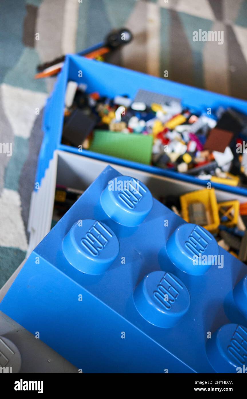 Vertical closeup of a container filled with Lego brand bricks and ...