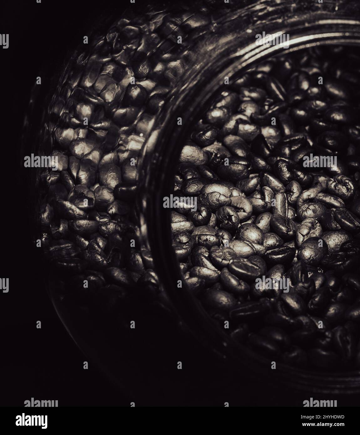 Top view of a glass jar filled with coffee beans, shot in grayscale ...