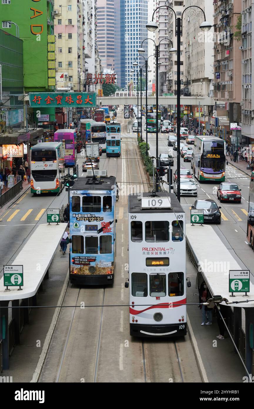Vertical shot of tall buildings and a busy street filled with buses and ...