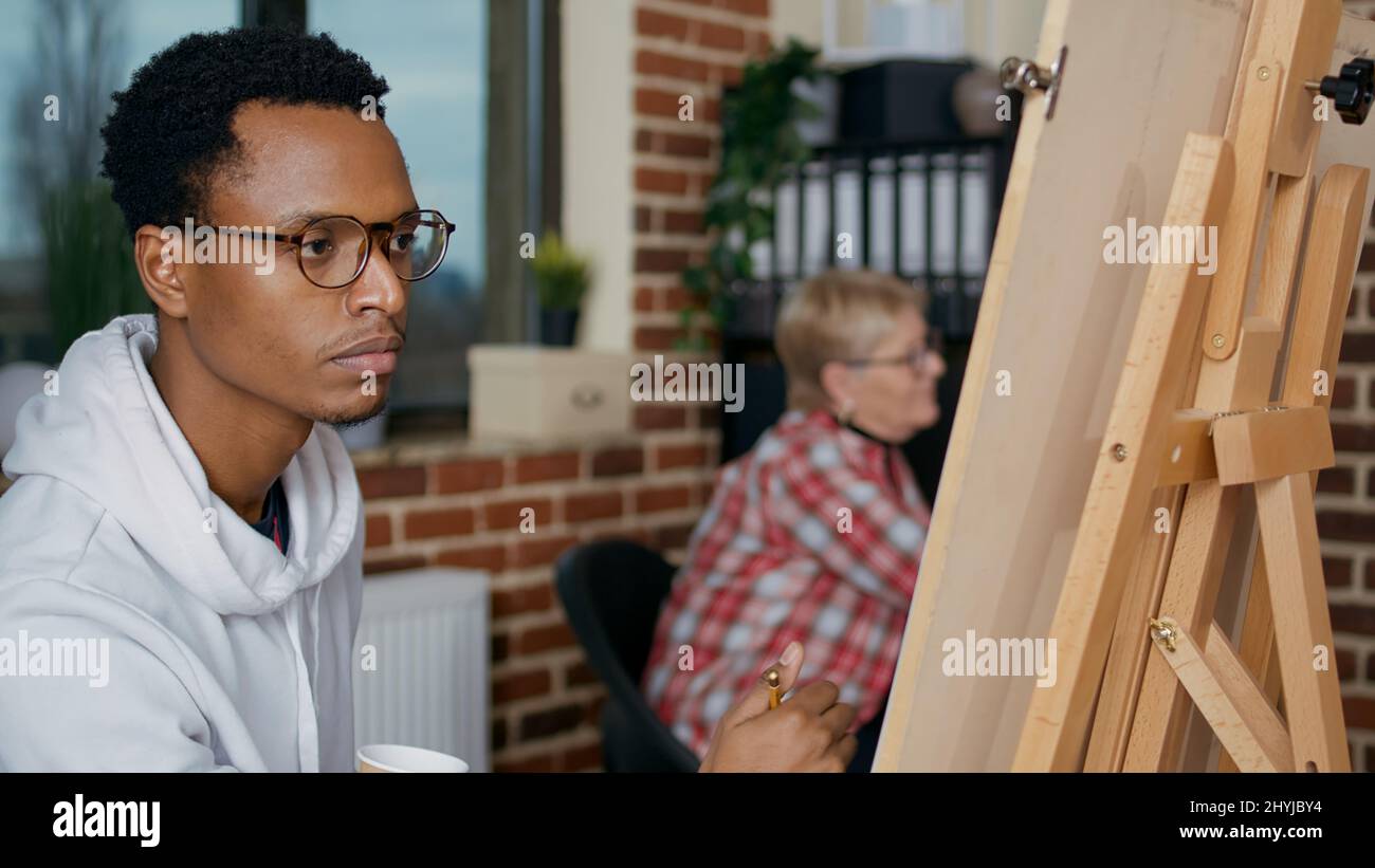 Portrait of young student using pencil on canvas to draw vase, learning ...