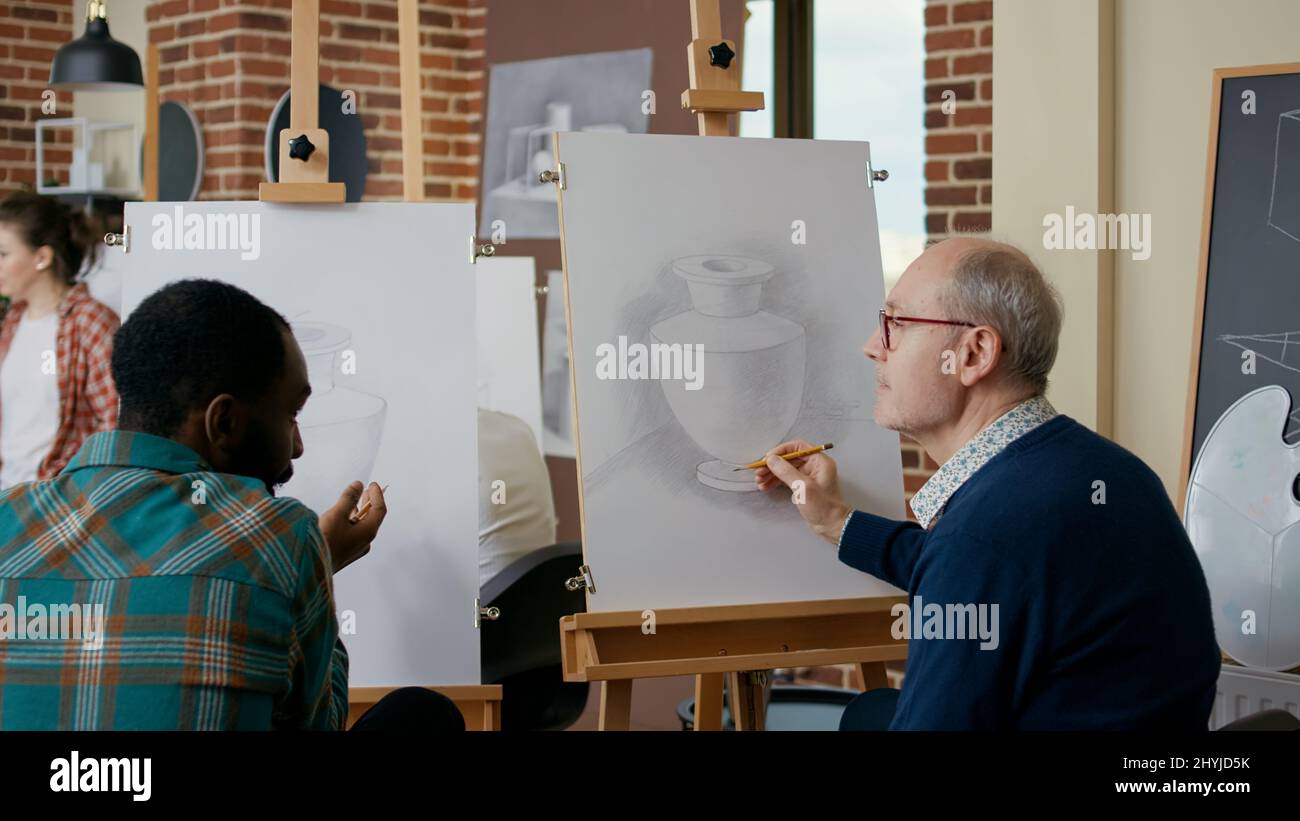 Diverse team of men attending art class lesson together to develop new ...