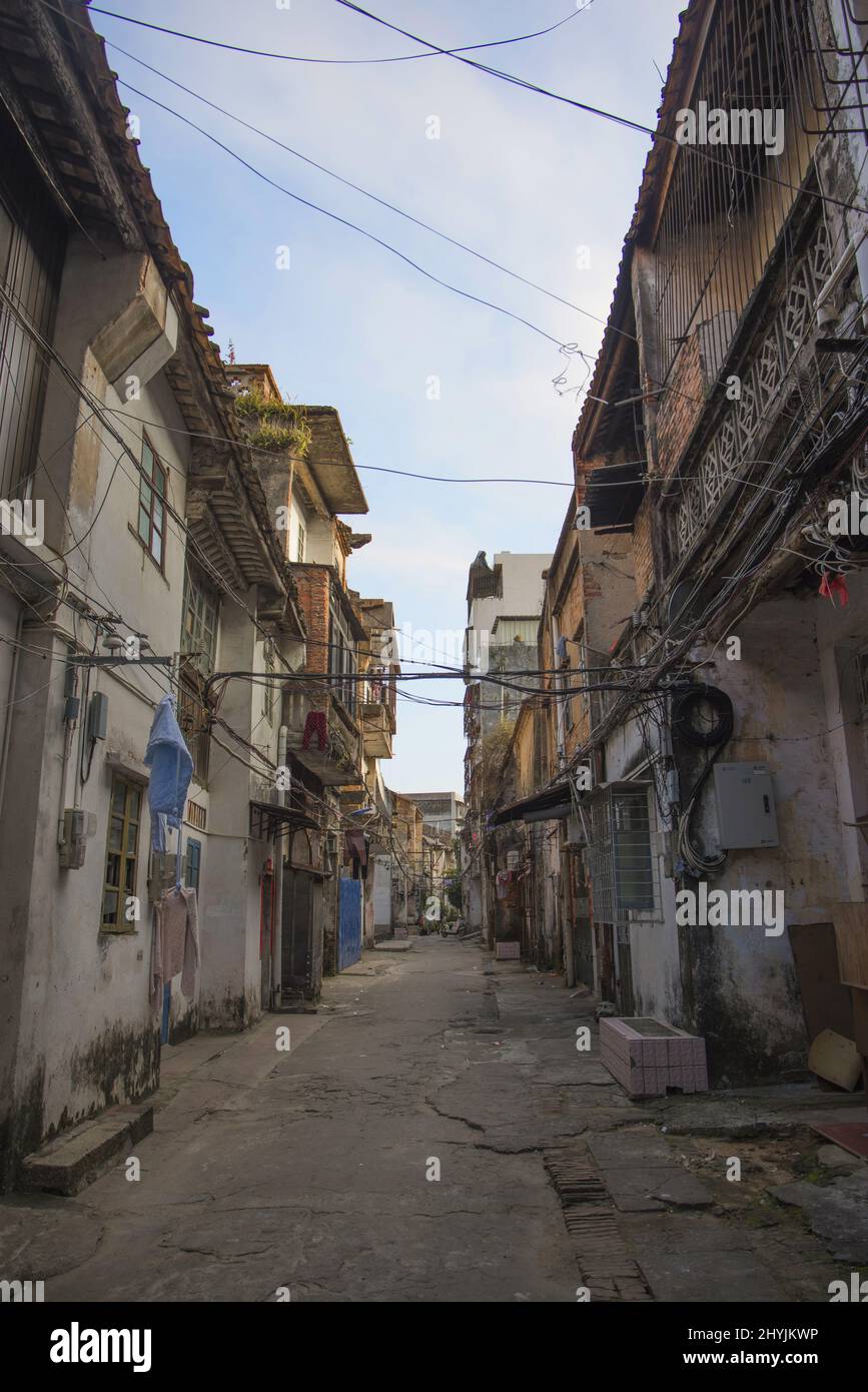 Vertical shot of an empty street between old rustic abandoned houses ...