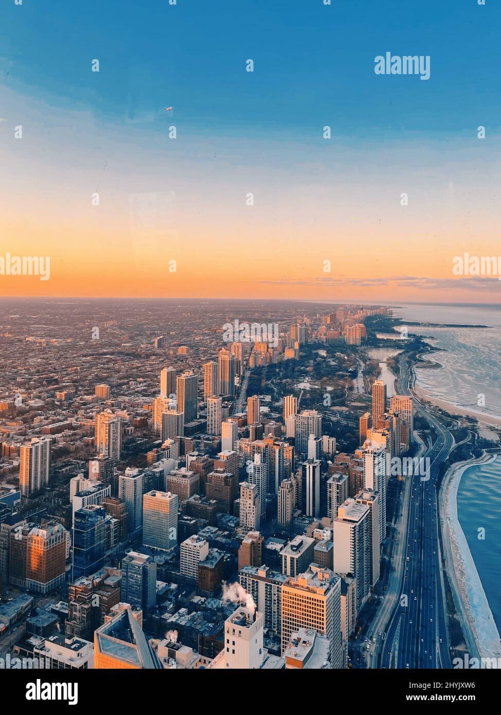 Aerial view of Chicago buildings along the sea at sunset Stock Photo ...