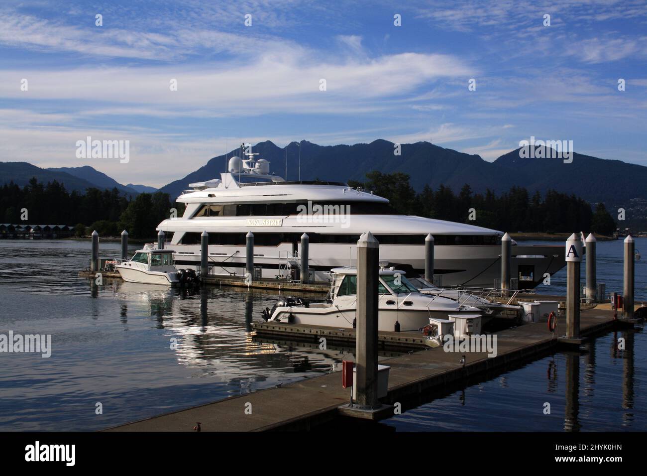 Luxury yacht in Coal Harbour, with trees and mountains in the ...