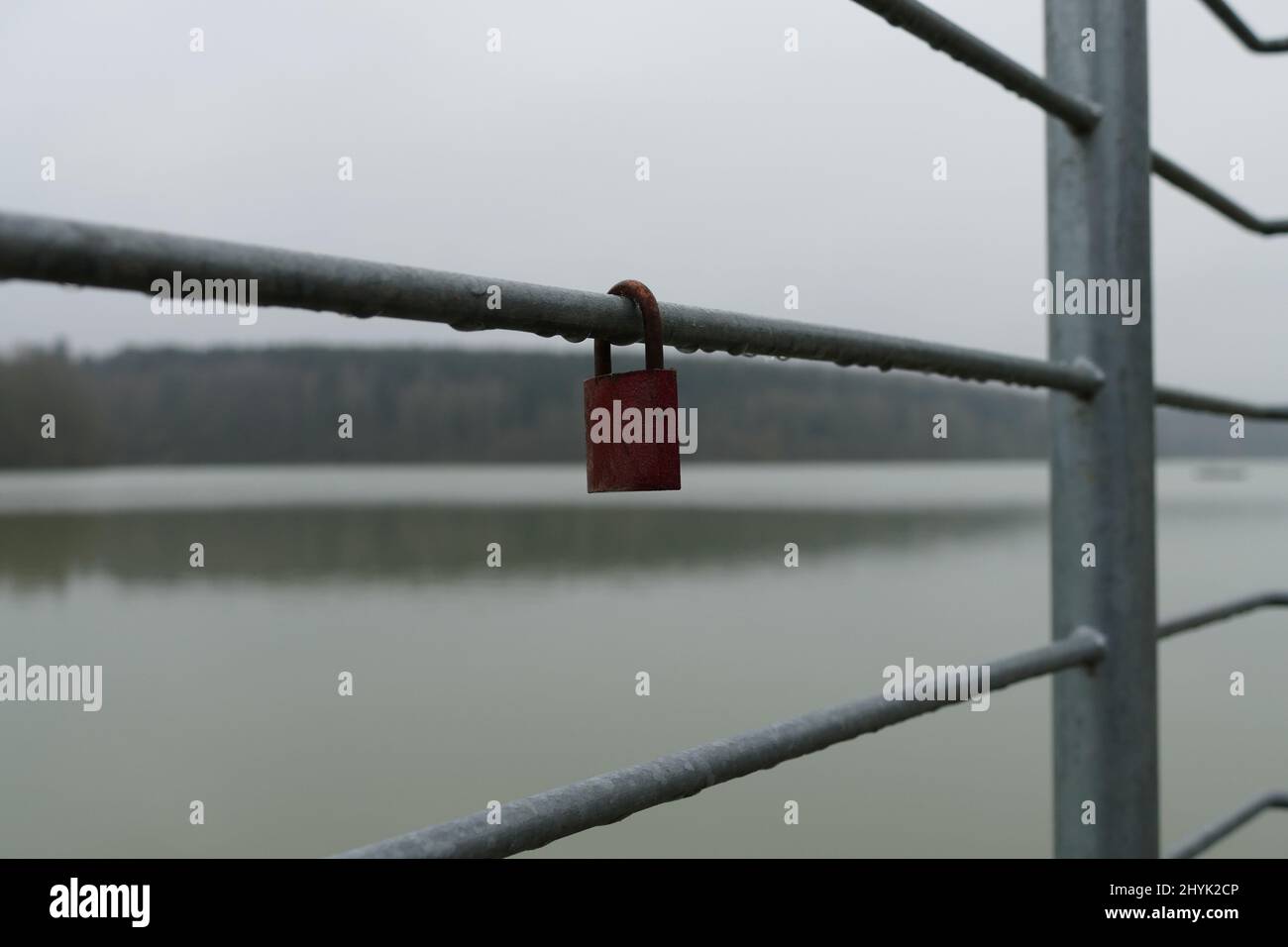 Closeup of the metal padlock hanging from the wet railing Stock Photo ...