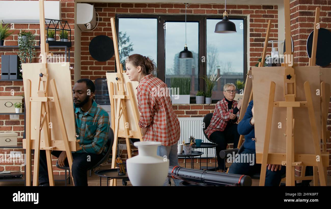 Creative students drawing on canvas in art class workshop with young ...