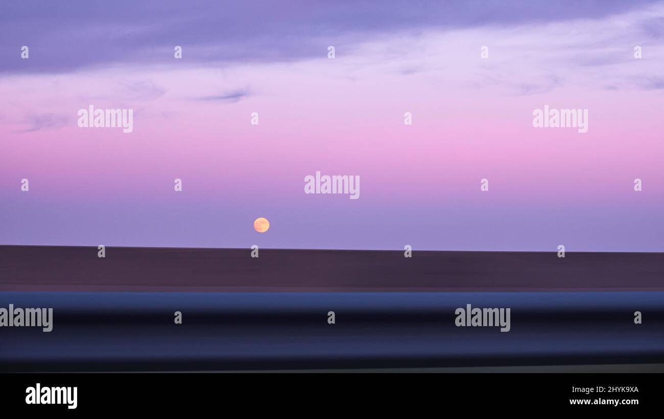 Big full moon with in the pink sky after the sunset Stock Photo - Alamy