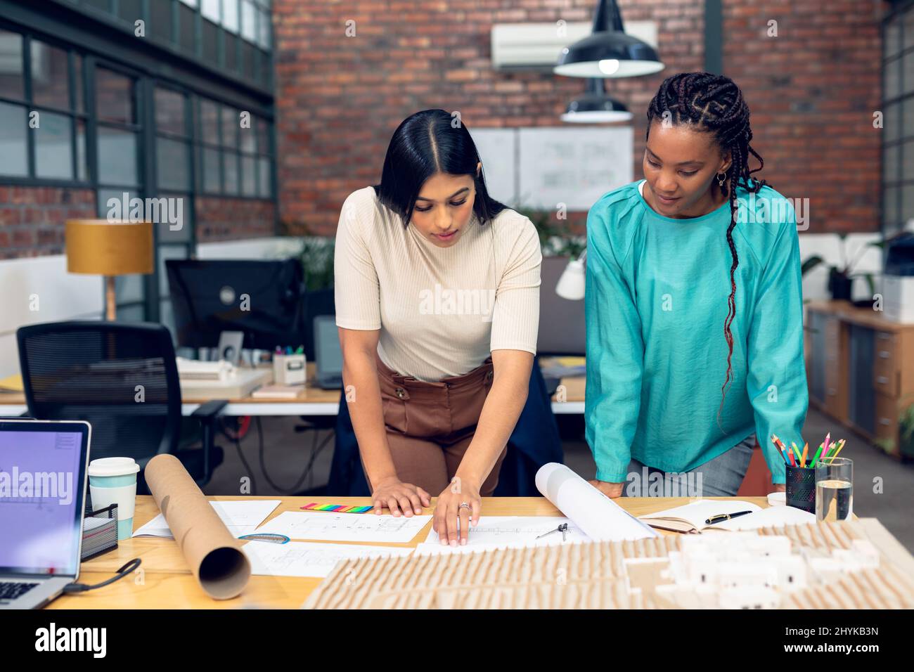 Biracial and african american young female architects discussing over ...