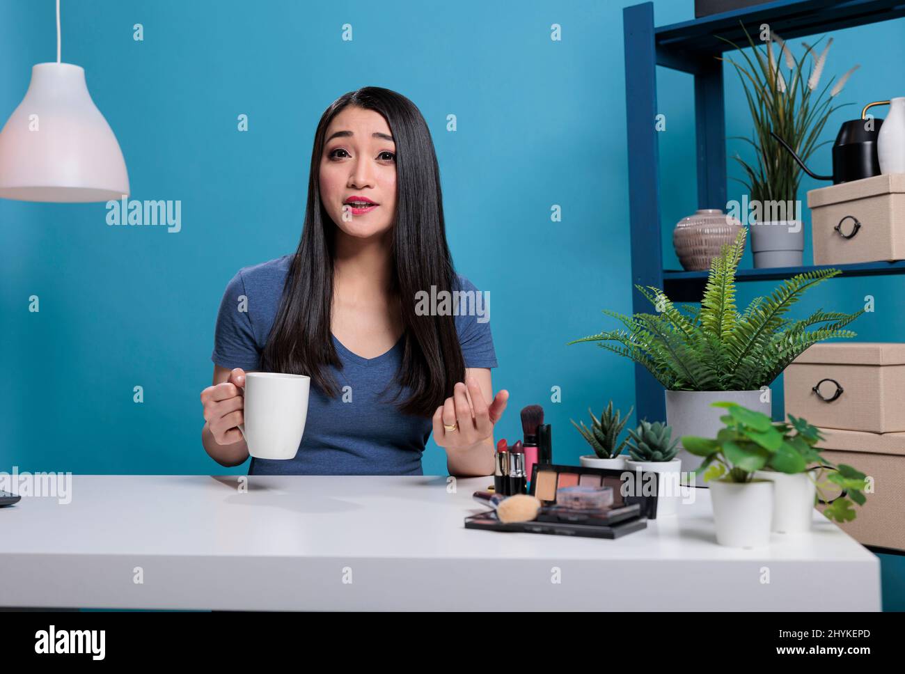 Portrait of social media influencer filming beauty podcast talking with ...
