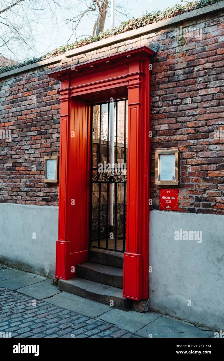 Red entrance to the restaurant in Nottingham old town, brick wall ...