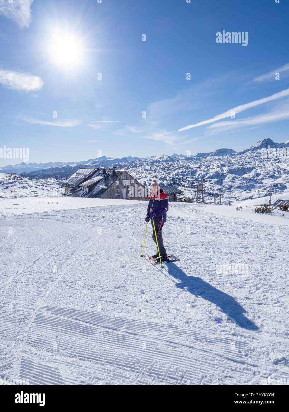 Blue sky above snowshoe hiker in winter landscape, snowy mountain peaks ...