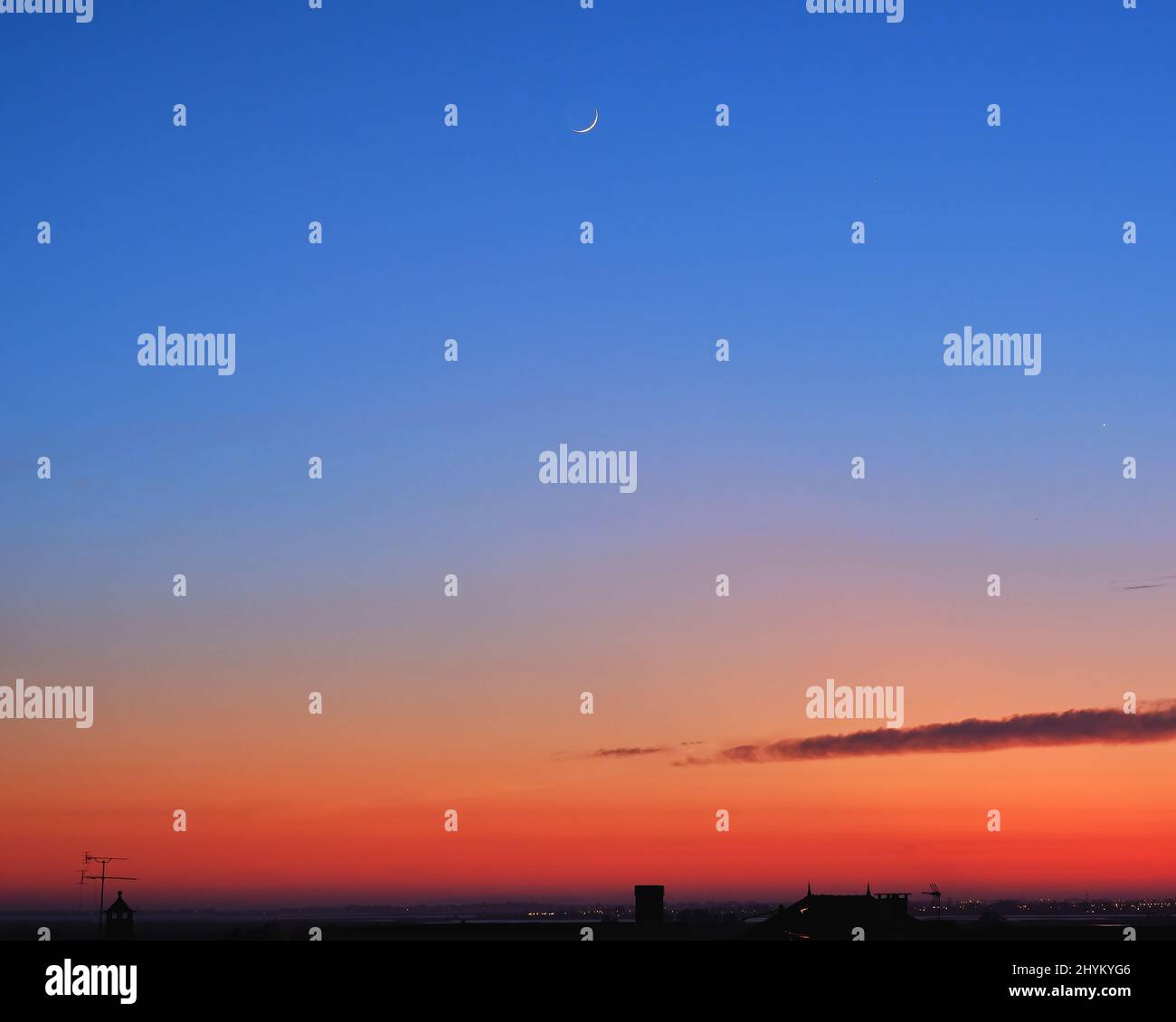 Simple sunset with blue and golden colours and the waxing crescent moon ...