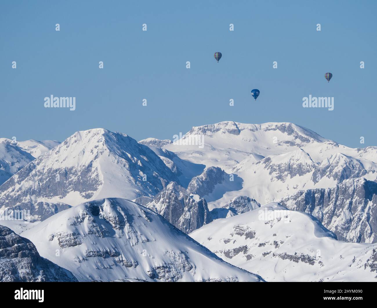 Hot air balloons flying over snow-covered Alpine peaks, view from ...