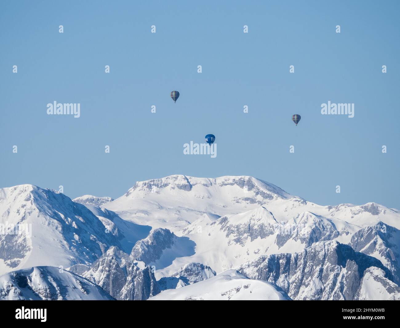 Hot air balloons flying over snow-covered Alpine peaks, view from ...
