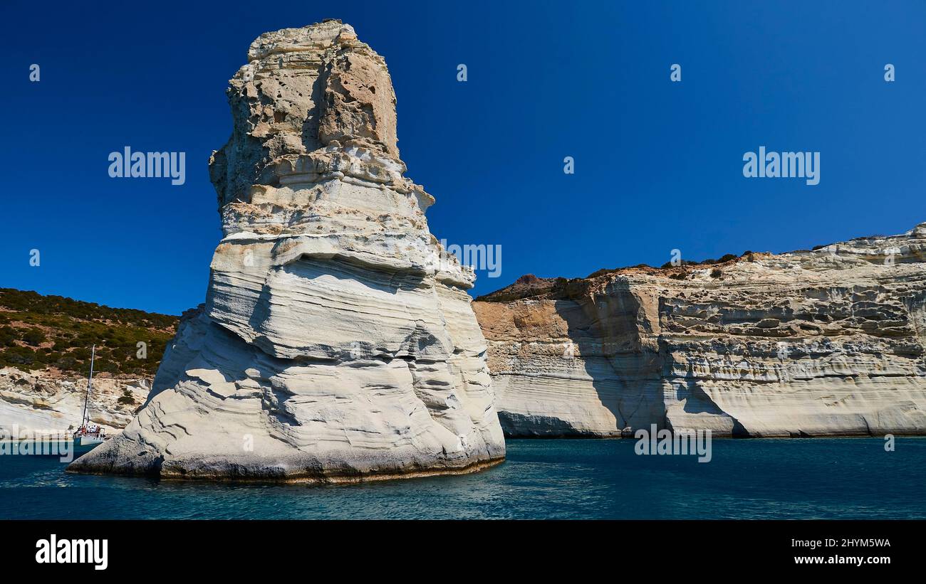 Volcanic rocks in the sea, sailboat, lava coast, blue cloudless sky ...