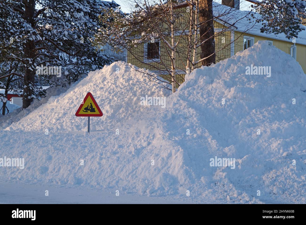 Huge snow piles and traffic sign with snowmobile in front of ...